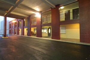 Um edifício com vários andares, entrada para garagem, janelas amplas e uma porta de garagem visível.