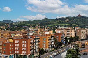 Paisagem urbana com edifícios altos, uma colina notável com um edifício histórico e céu claro.