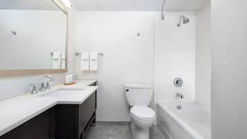 Um banheiro moderno com pia, vaso sanitário e banheira brancos.