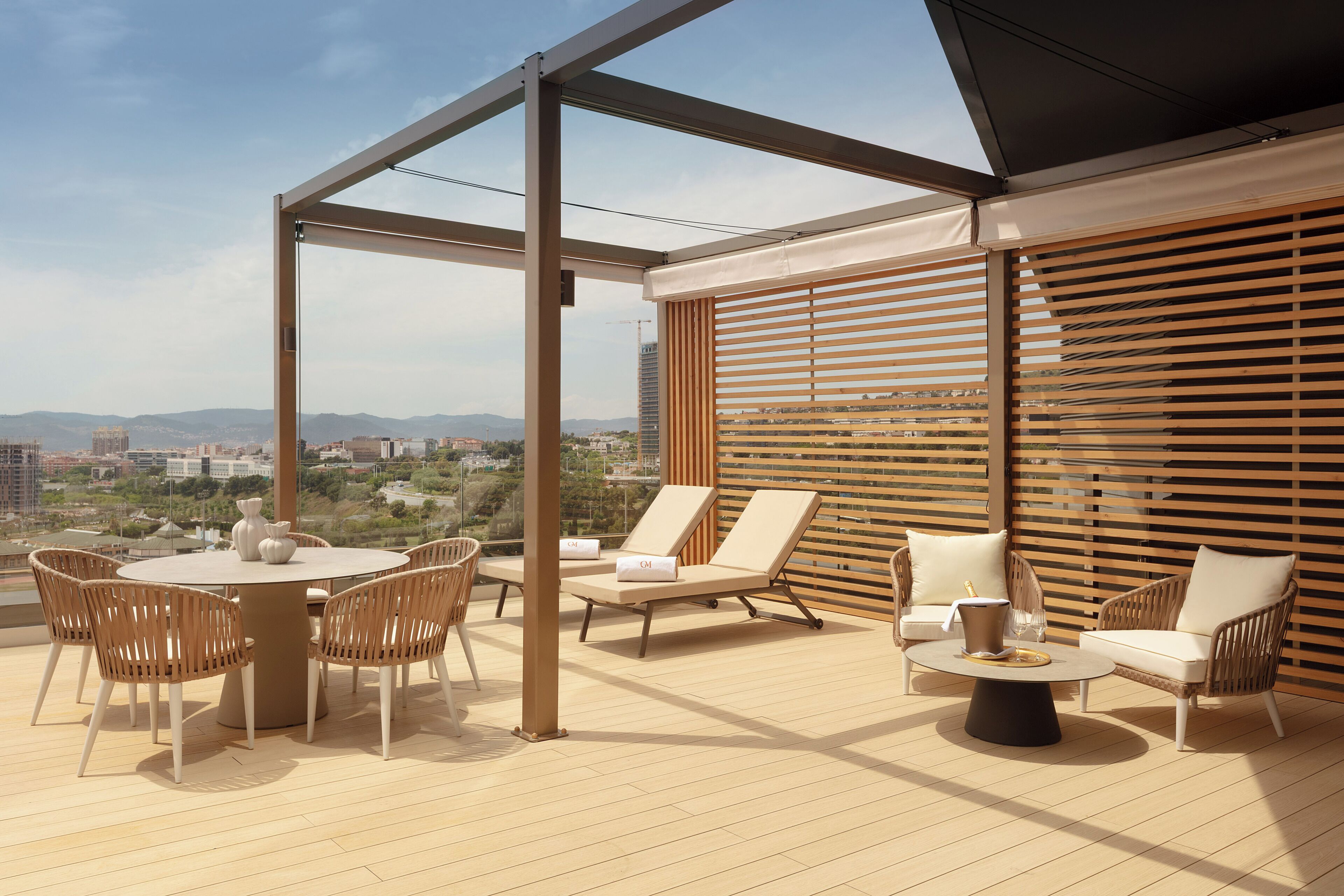 Terraço no telhado com mesa redonda e cadeiras, mesa de centro e duas poltronas.