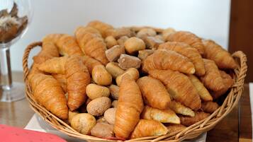 Uma cesta com diversos tipos de pães e doces.