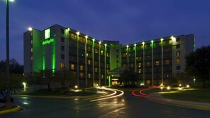 Um hotel Holiday Inn com design moderno, destacando uma entrada imponente e vários andares.