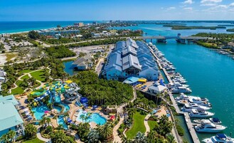 Resort com ampla área de piscina, parque aquático e marina com barcos.