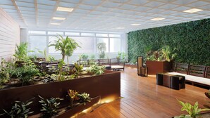 Um espaço interior moderno com piso de madeira, parede verde e diversas plantas.