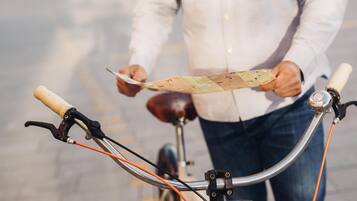 Uma bicicleta com um mapa e uma pessoa segurando-o.