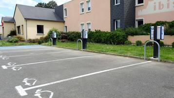 Uma área de estacionamento com espaços demarcados para bicicletas e estações de carregamento para veículos elétricos.