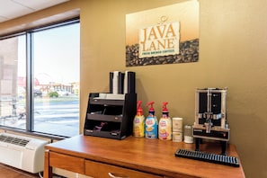 Interior de cafeteria com um letreiro escrito 'JAVA LANE' e uma máquina de café.