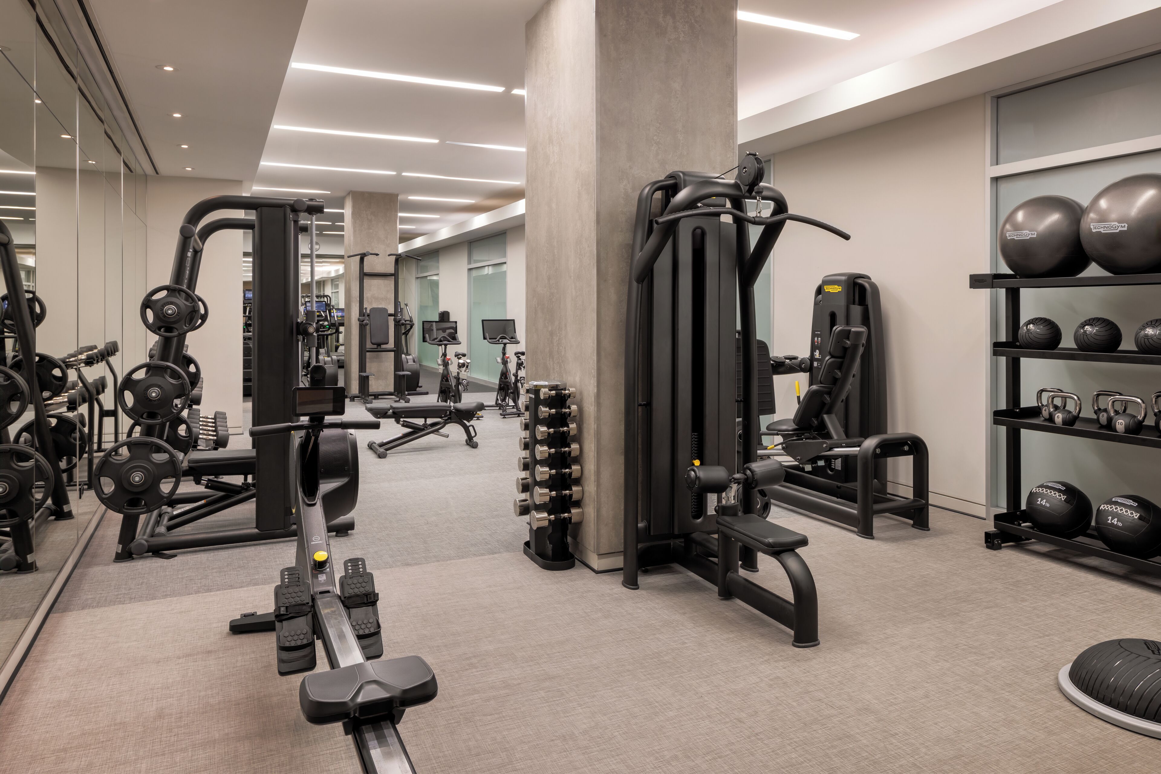 Uma academia moderna com diversos equipamentos de exercício, incluindo aparelhos de musculação, pesos livres e máquinas de cardio.