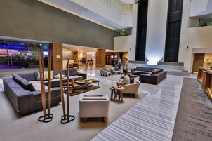 Um hall espaçoso com design moderno, com sofás, uma mesa de centro e um bar.