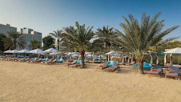 Uma praia privada, espreguiçadeiras, guarda-sóis de praia