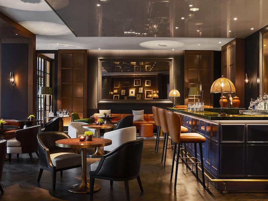 Uma área de bar moderna, com lugares sentados e balcão.