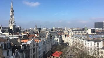 Paisagem urbana com edifícios históricos, uma torre de igreja imponente e um arranha-céu moderno.