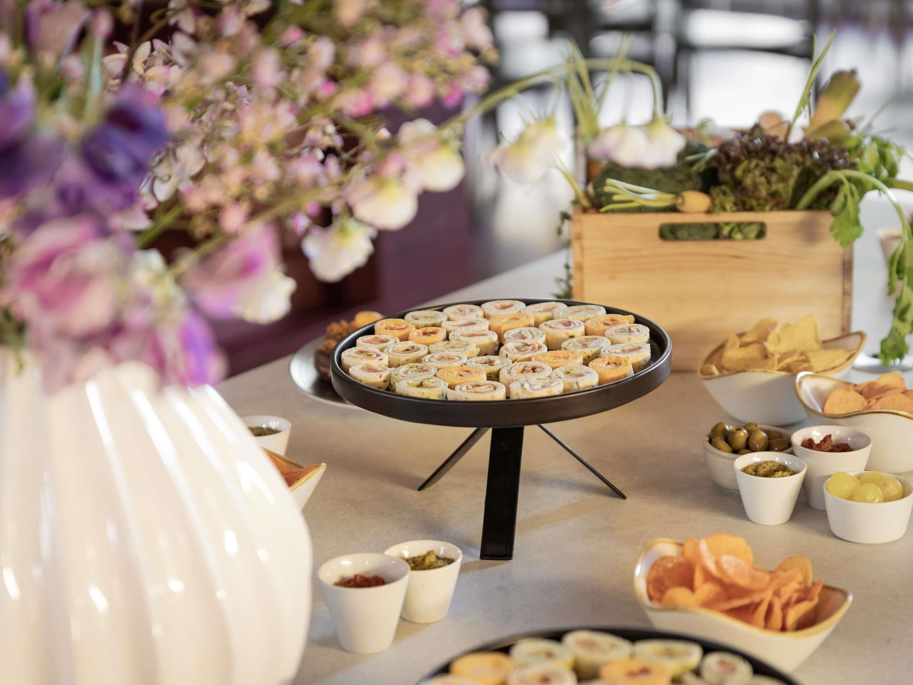 Uma mesa de buffet com diversos alimentos e pequenas tigelas de acompanhamentos.