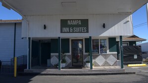 Um edifício com uma placa que diz 'NAMPA INN & SUITES' e uma entrada visível.