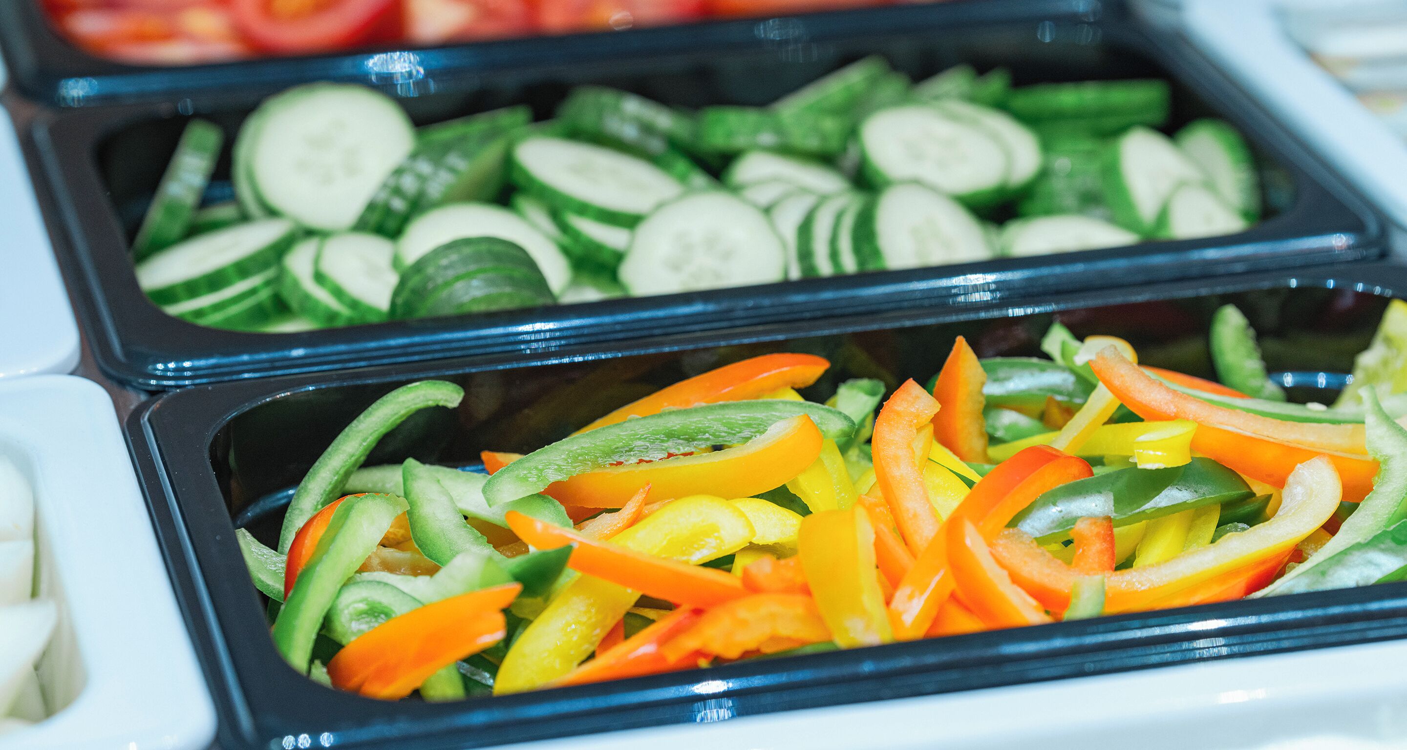 Buffet com diversos vegetais fatiados.