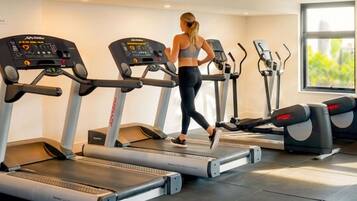 Uma academia com esteiras e equipamentos de ginástica.