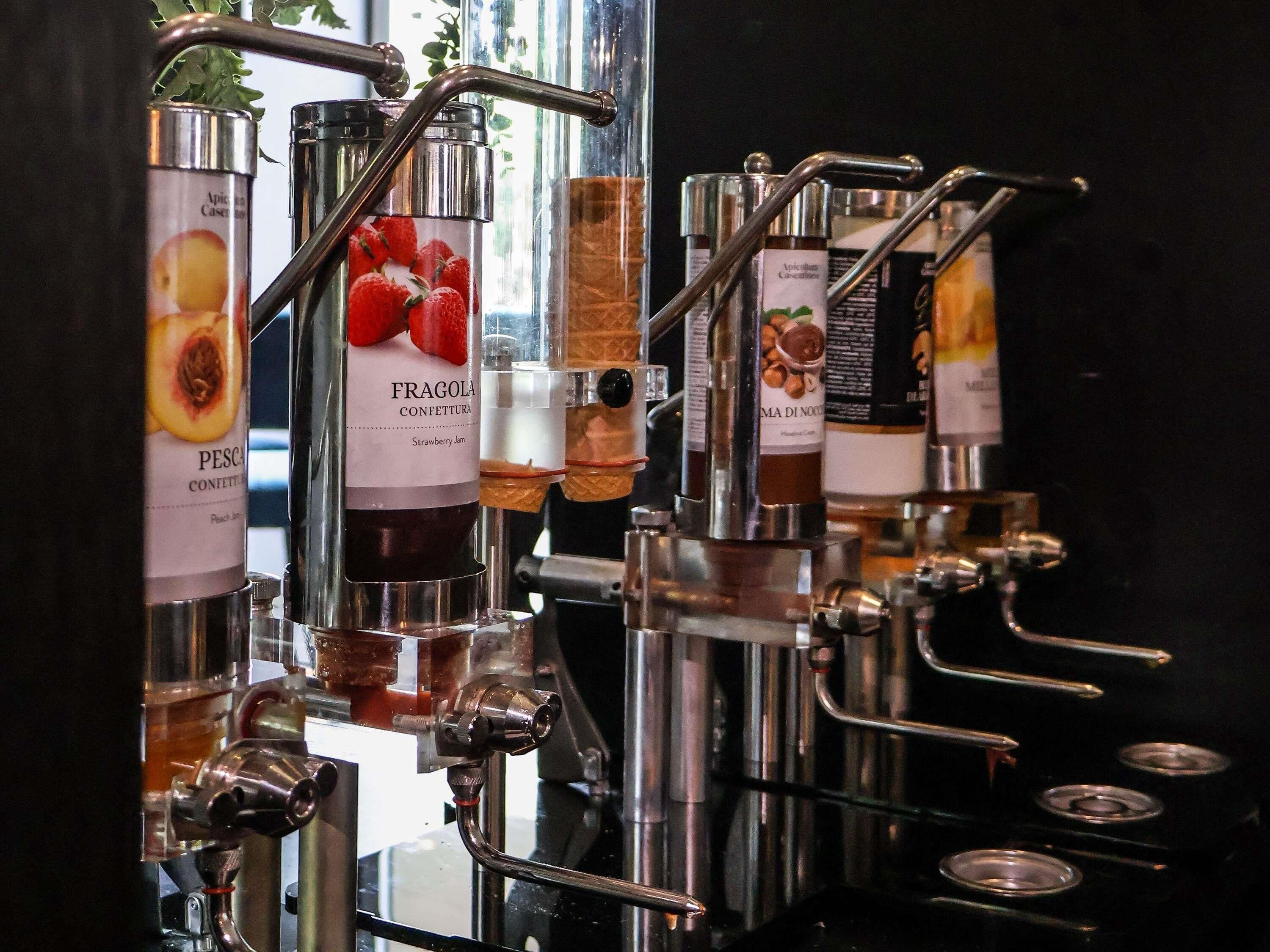 Máquina de café com vários dosadores, cada um identificado com diferentes tipos de café.