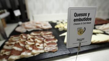 Exposição de queijos e charcutaria em um buffet de hotel.