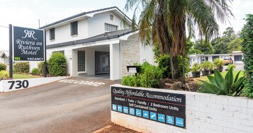 Um motel chamado Riviera na Ruthven, com uma placa indicando quarto disponível. Possui uma entrada convidativa com um letreiro de 'BEM-VINDO' no chão, um apartamento de dois quartos e diversos serviços como Wi-Fi, AUSTAR e TV LED.
