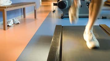 Uma academia com equipamentos de exercício, um banco e um par de tênis.