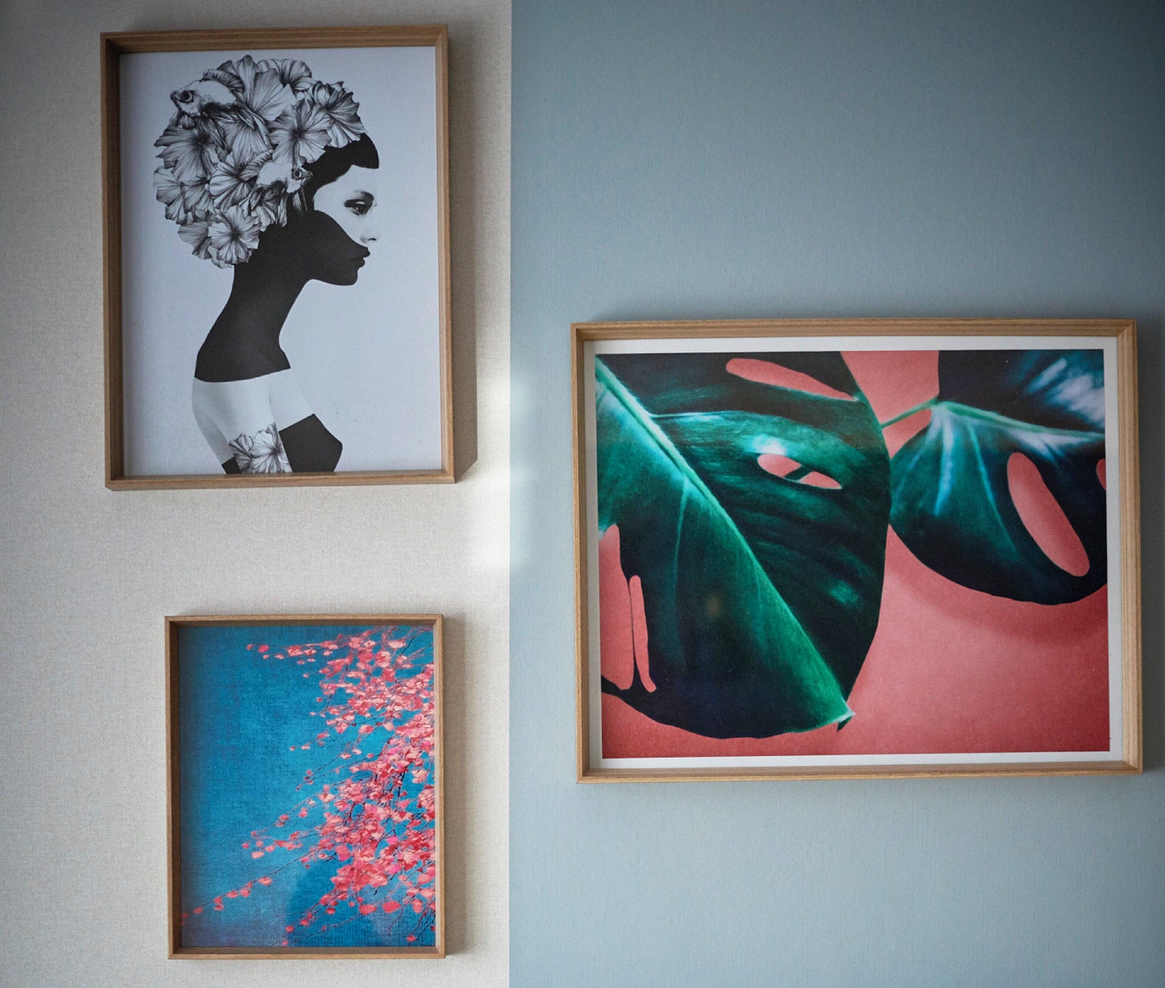 Três obras de arte emolduradas em uma parede.