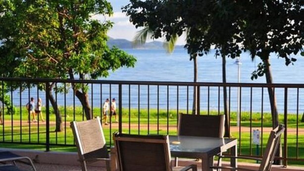 Uma área de estar ao ar livre com vista para um corpo d'água e um parque.