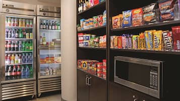 Uma área com máquinas de venda automática, oferecendo diversos lanches e bebidas.