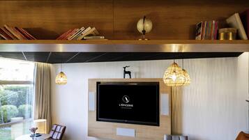 Uma sala de estar moderna com televisão de tela plana, estantes de madeira com livros, um globo terrestre e uma decoração com cabeça de veado.