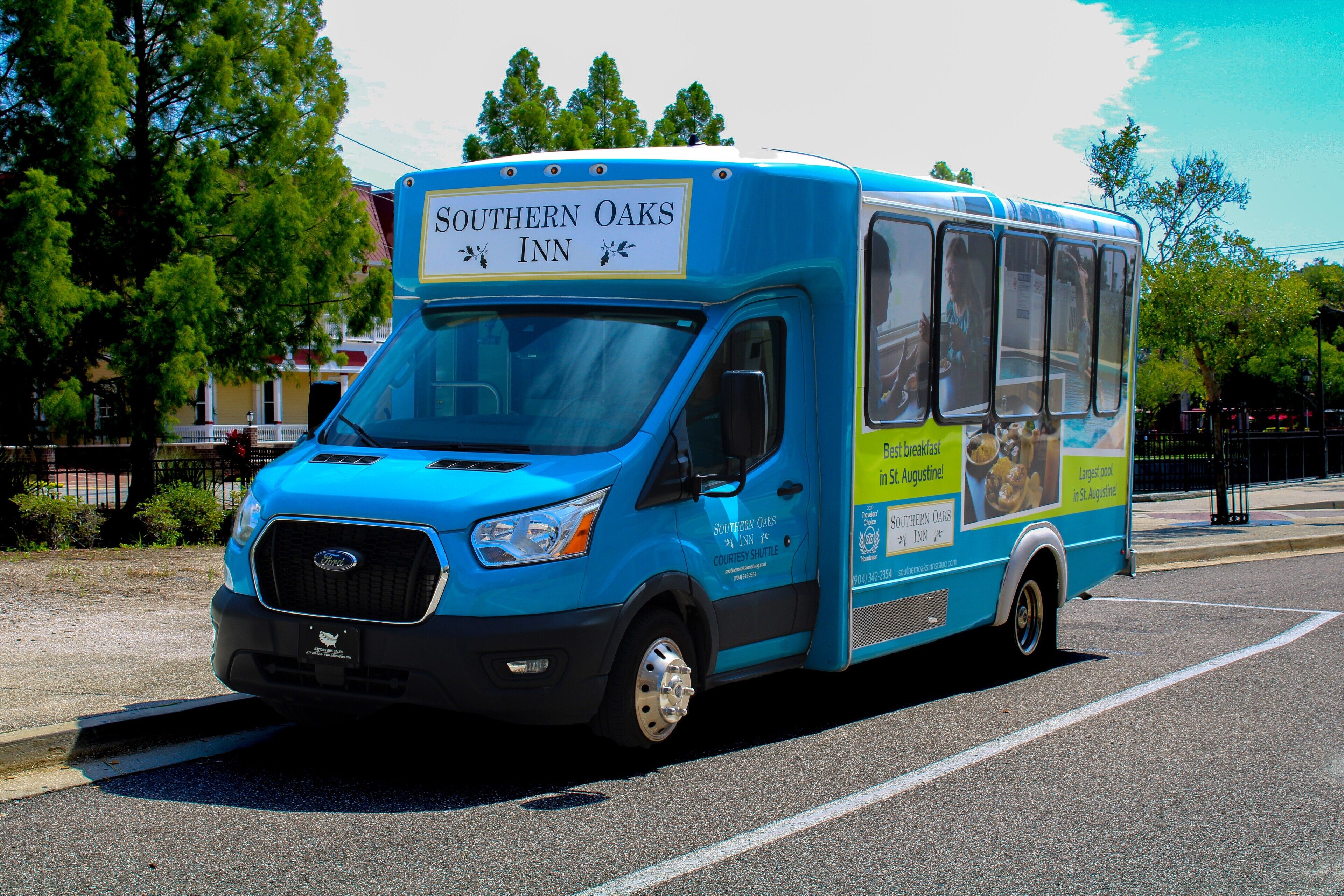 Um ônibus azul de transporte com a inscrição 'Southern Oaks Inn' na frente.