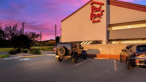 Um edifício com uma placa que diz 'Red Roof Inn'.