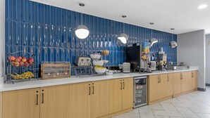 Cozinha moderna com bancada comprida, armários de madeira e painel de parede azul.