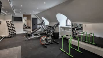 Uma academia moderna com diversos equipamentos de exercício, incluindo halteres, esteira e bicicleta ergométrica.