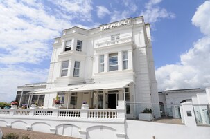 Um edifício branco com uma placa que diz 'The Palace'.