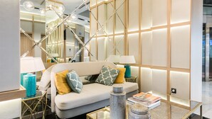 Uma sala de estar moderna com sofá, mesa de centro e luminárias decorativas.