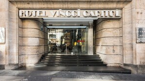 Entrada do Hotel Vincci Capitol, com fachada de pedra e o nome do hotel em destaque.