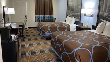 Quarto de hotel com duas camas, uma escrivaninha, uma cadeira, um computador e vista para a cidade.