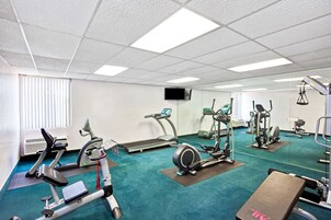 Uma academia com diversos equipamentos de exercício, incluindo esteiras, elípticos e aparelhos de musculação.