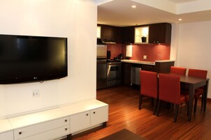 Cozinha moderna com televisão de tela plana, piso de madeira e backsplash com azulejos vermelhos.