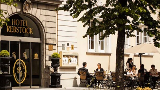 Entrada de um hotel com uma placa que diz 'HOTEL REBSTOCK'.