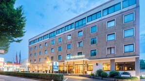 Um hotel com vários andares e fachada moderna, com uma placa Best Western bem visível.