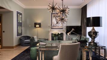 Uma sala de estar moderna com uma mesa de centro de vidro, um sofá confortável, uma luminária elegante e um lustre decorativo.
