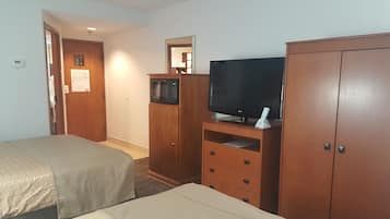 Quarto de hotel com duas camas, televisão, micro-ondas e guarda-roupa.