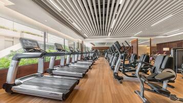 Academia moderna com esteiras, elípticos e equipamentos de musculação.