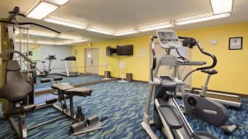 Centro de atividades físicas com esteiras, elípticos e aparelhos de musculação.