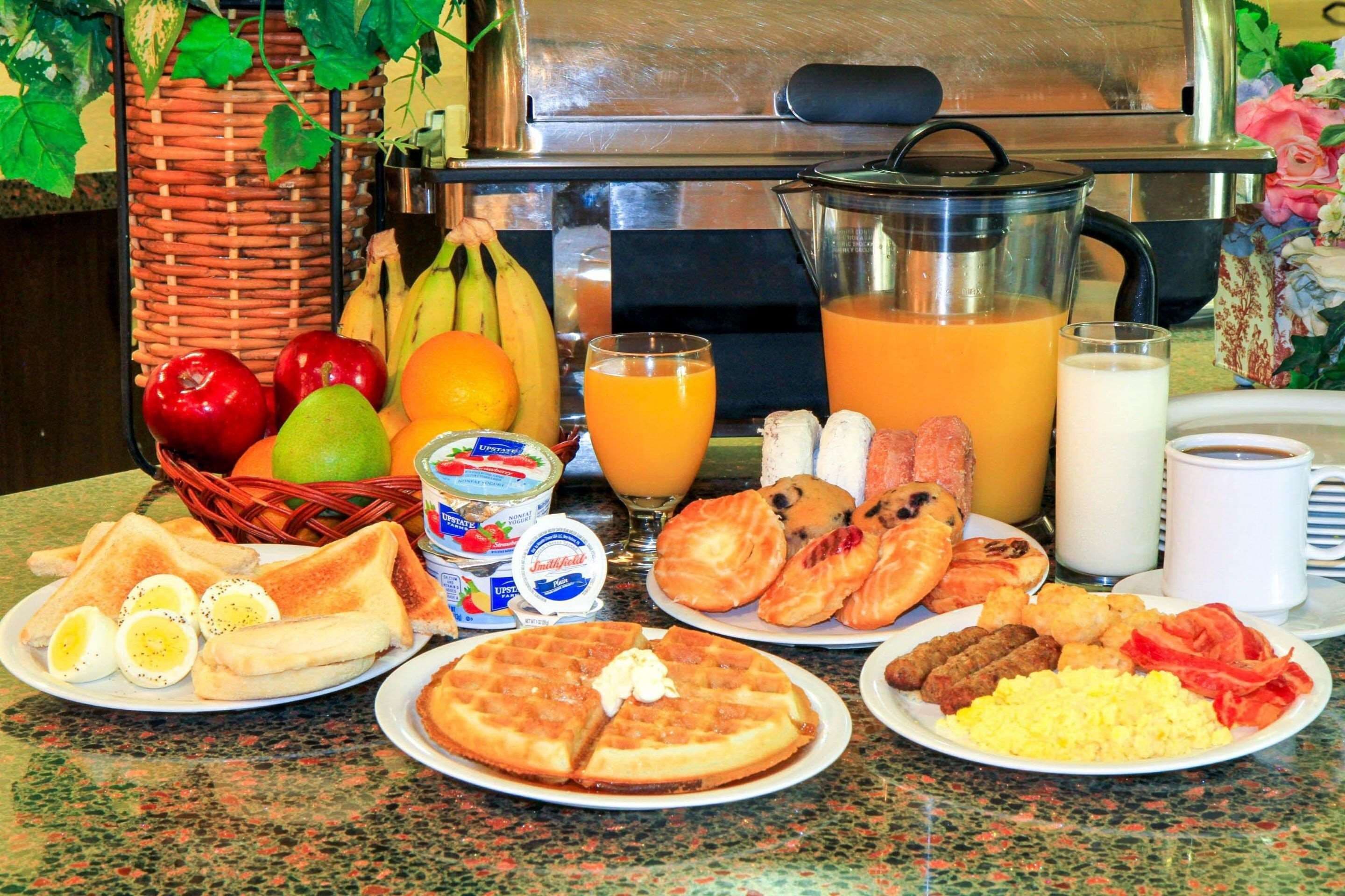 Mesa de café da manhã com diversos alimentos e bebidas.