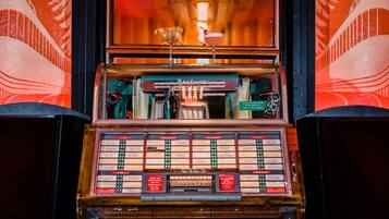 Um jukebox antigo com opções de bebidas e uma entrada para moedas.