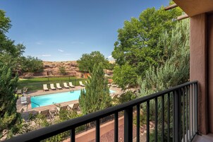 Área de piscina com espreguiçadeiras e vista para uma paisagem montanhosa.