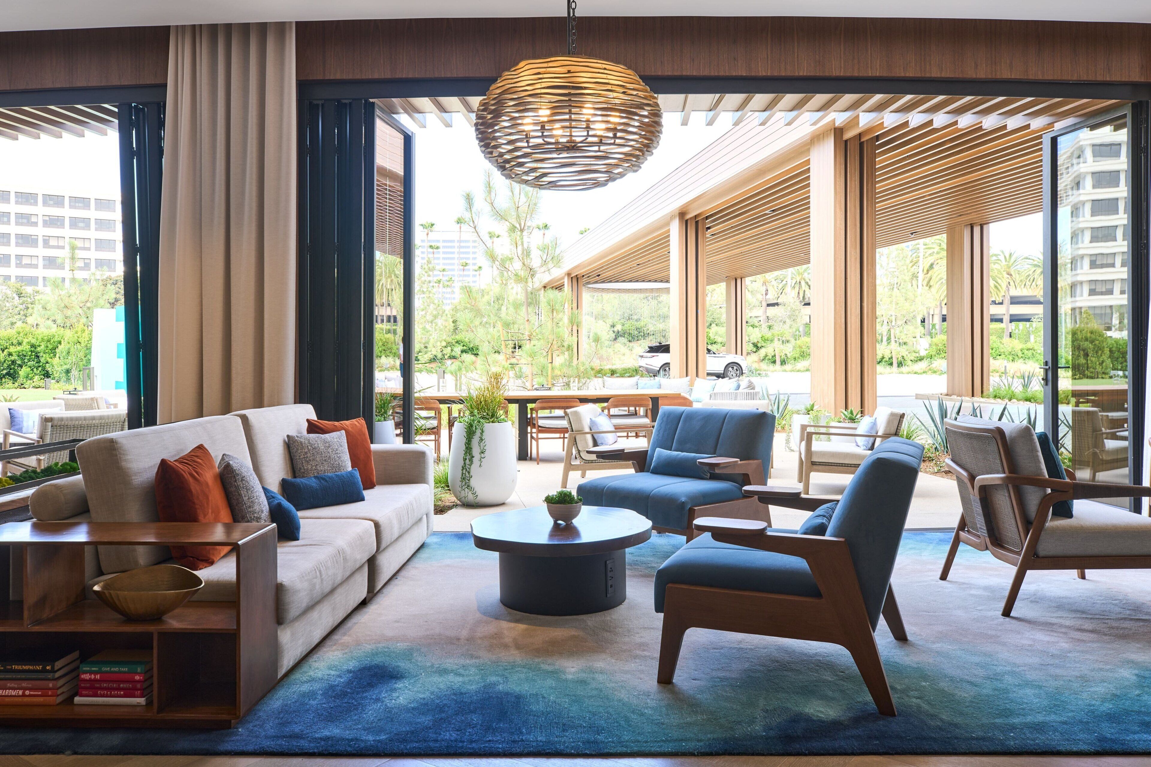 Uma sala de estar moderna com sofá, poltronas, mesa de centro e luminária pendente.