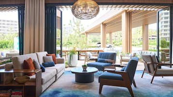 Uma sala de estar moderna com sofá, poltronas, mesa de centro e luminária pendente.