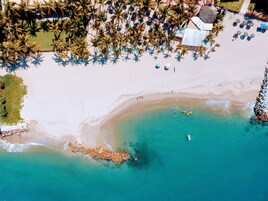 Na praia, espreguiçadeiras, guarda-sóis, toalhas de praia 